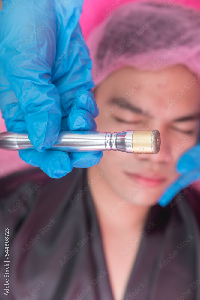 An Esthetician shows the diamond peel tool used for a microdermabrasion ...