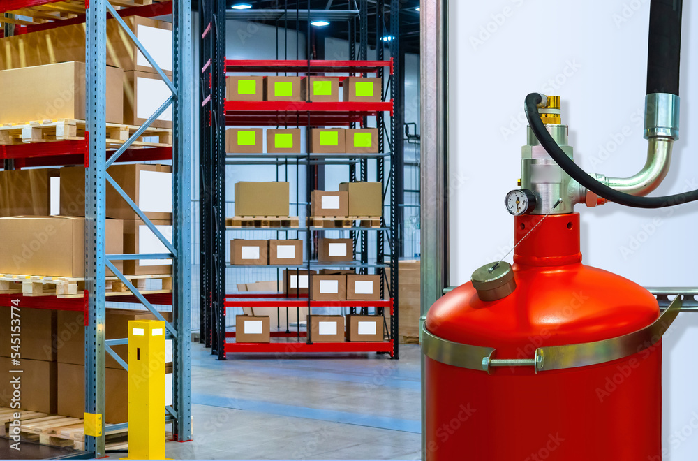 Fire safety equipment. Big red fire extinguisher inside warehouse ...