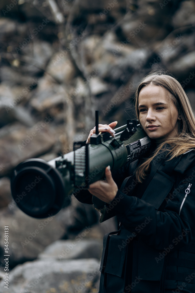 Guy and girl in military with bazooka and machine guns pose for camera ...