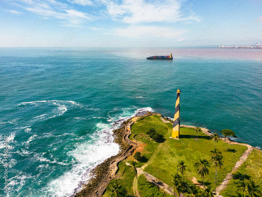 Aerial view of lighthouse Faro San Souci and cargo container ship on ...