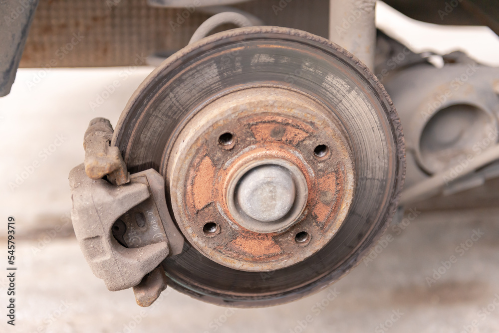 Heavily worn brake disc. Car brake disc after removing the wheel. A ...