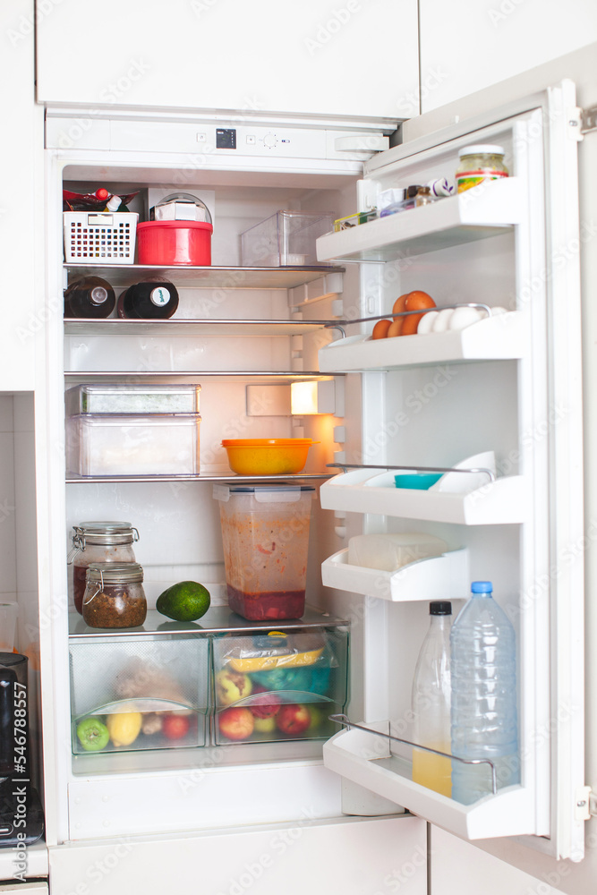 Open fridge in the kitchen. House organization. Stock Photo | Adobe Stock