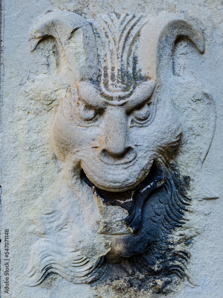 Old bas-relief of devil on the castle wall Stock Photo | Adobe Stock