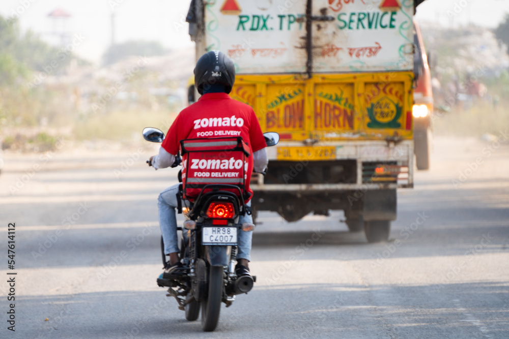 bike rider delivery boy with hot box branded with zomato the food tech ...