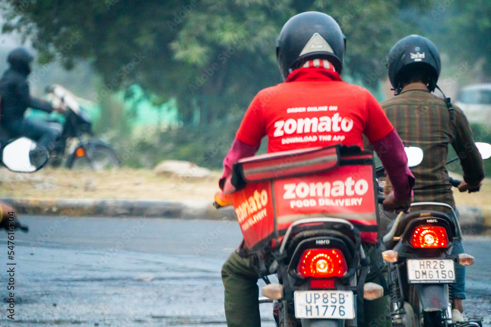Photo Stock bike rider delivery boy with hot box branded with zomato ...