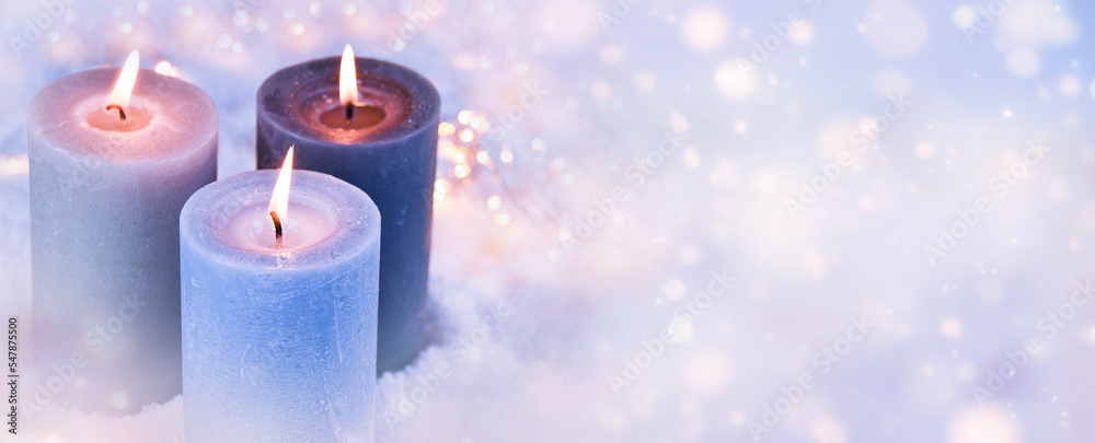 Three burning Christmas Advent candles with magic bokeh lights in snow ... Three burning Christmas Advent candles with magic bokeh lights in snow ...