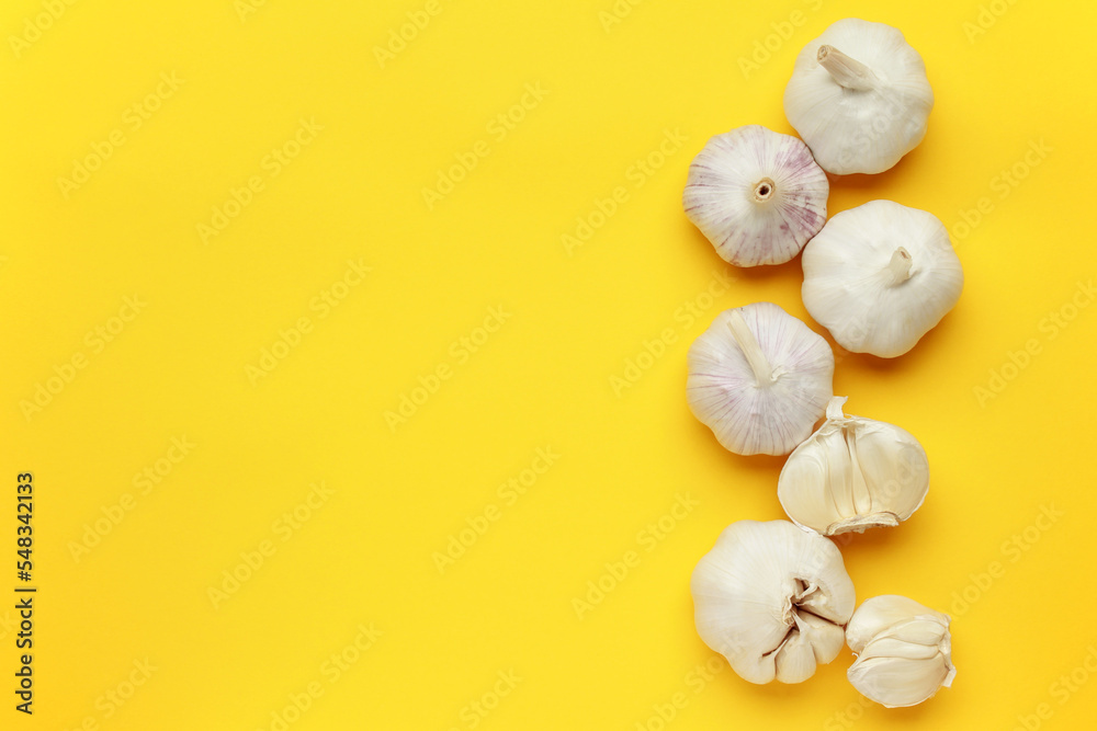 Fresh white unpeeled head bulb of garlic on yellow color background ...