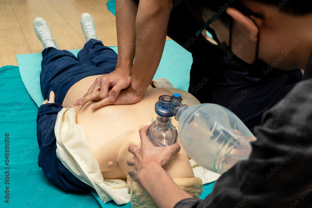 Demonstrating CPR (Cardiopulmonary resuscitation) training medical procedure on CPR doll in the ...