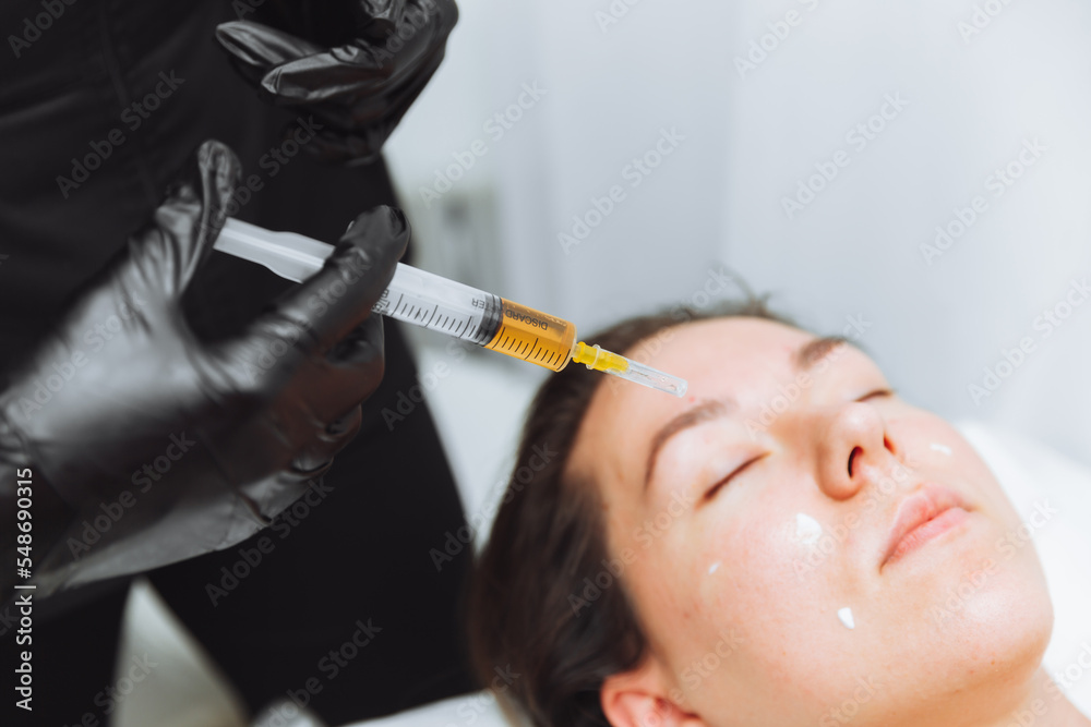 Plasma injection into the hair on a woman 's head .a cosmetologist ...