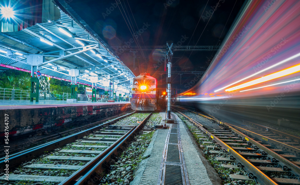 Railway Station, one standing train and one moving train. Stock Photo ...