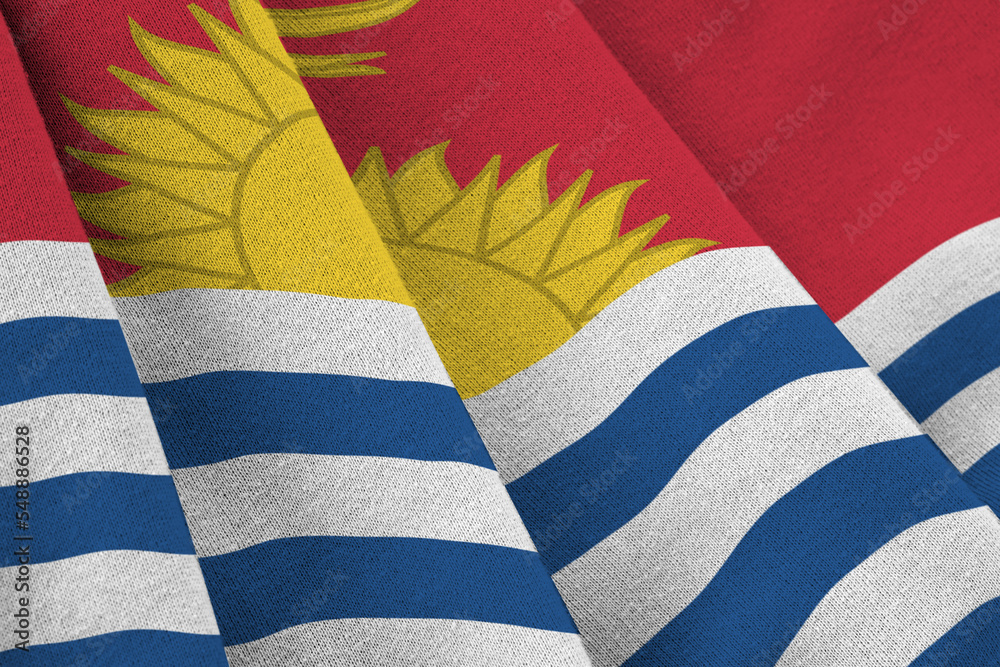 Kiribati flag with big folds waving close up under the studio light ...