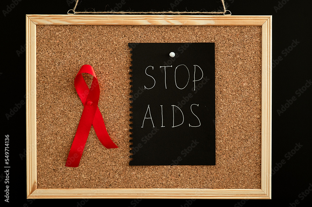 World AIDS Day. Red ribbon and STOP AIDS note as a symbol of struggle ...
