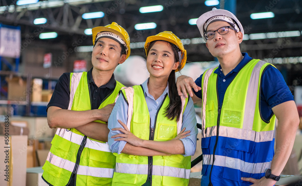 Team of three male employees in uniforms and helmets move packages from ...
