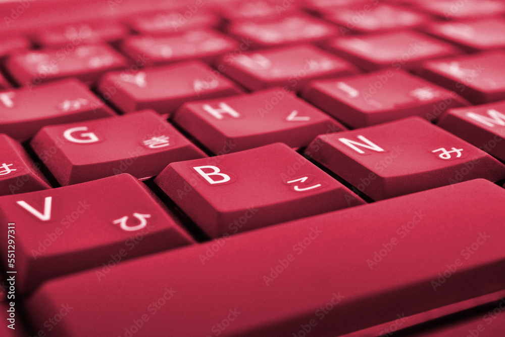 Japanese typing. Bright red laptop keyboard. Symbols on buttons of ...