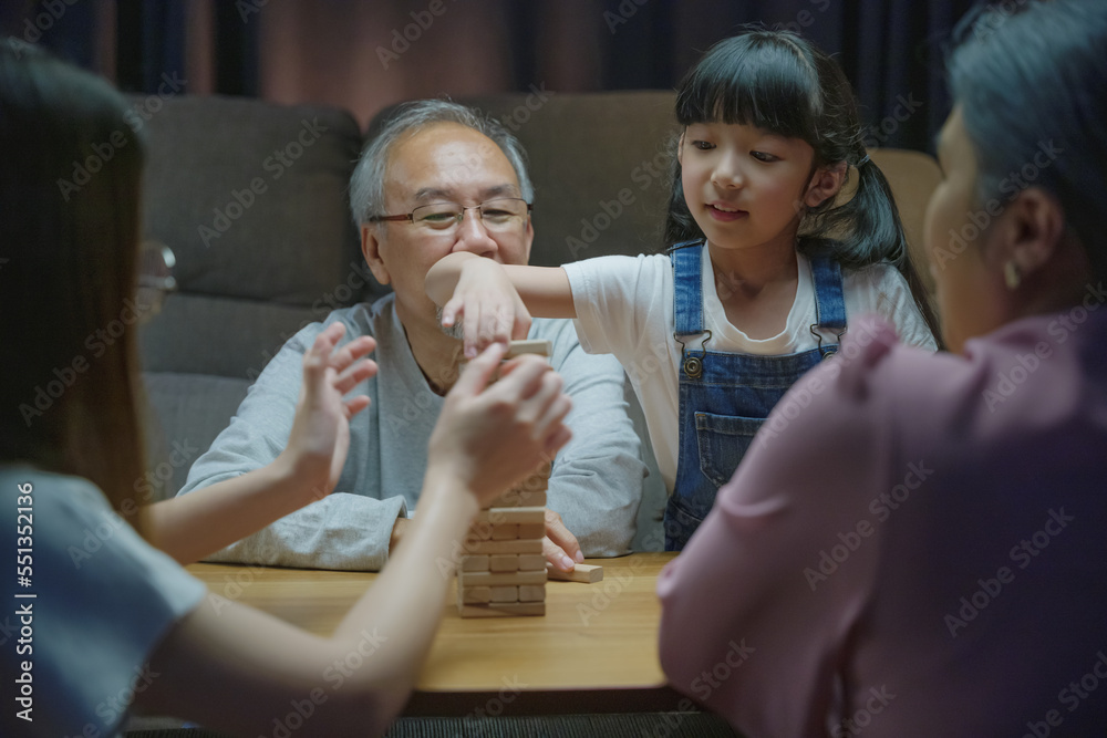 Happy grandparents Asian family enjoy playing toy block with little daughter and mother together ...