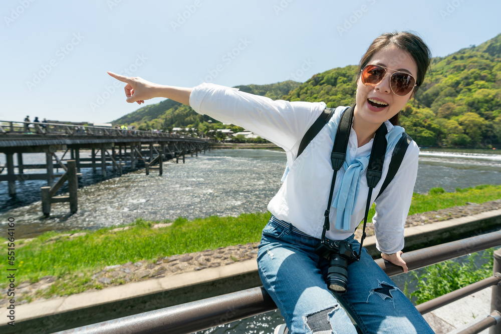 happy asian Japanese woman visitor wearing sunglasses and pointing ...