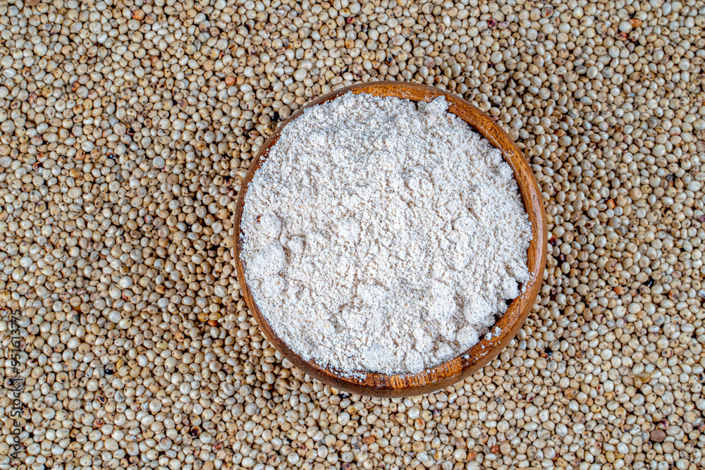 Top view of Sorghum grains and sorghum flour in a bowlson white ...