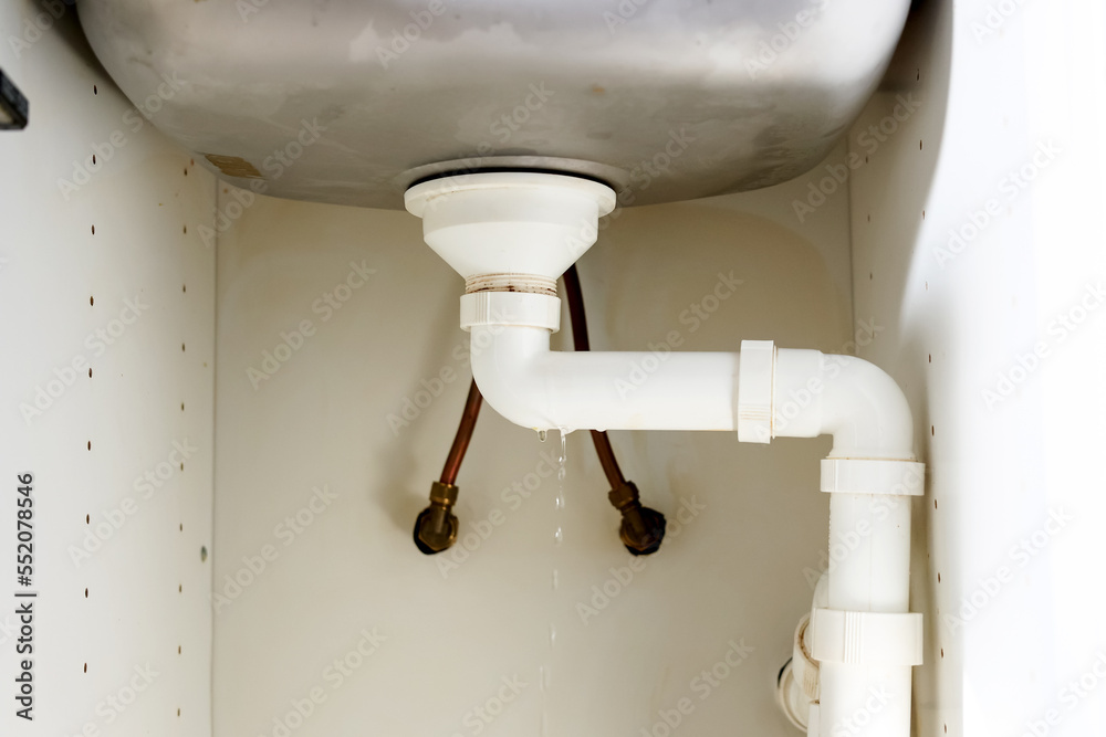 Kitchen sink plumber damage, water dripping from the pipe under the ...