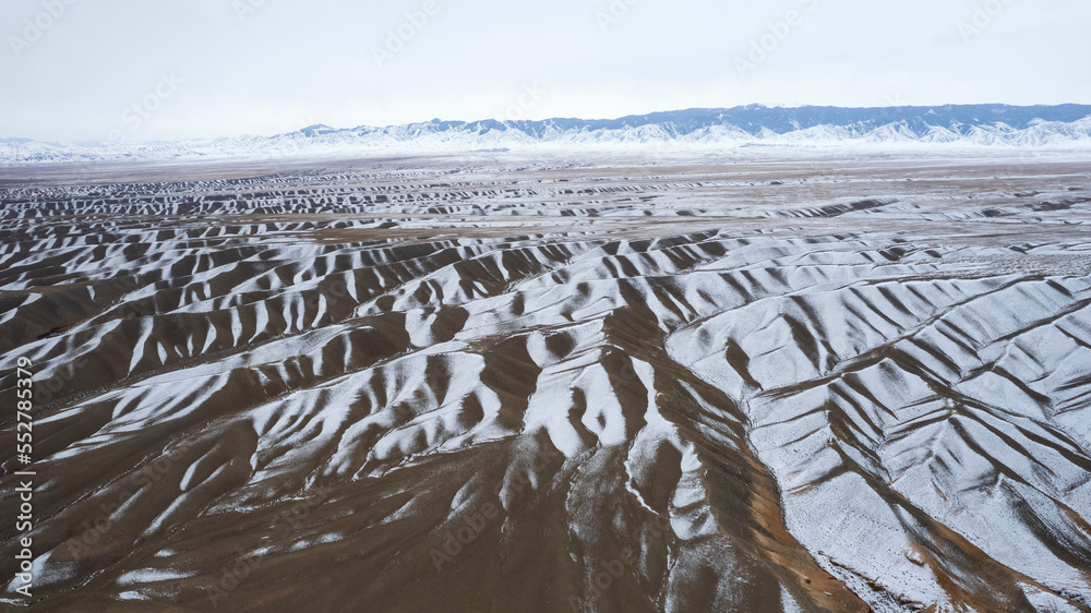 The high hills are like waves covered with snow. Black mountains with ...