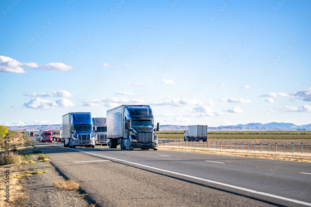Convoy of the different big rigs semi trucks carry cargo in semi ...