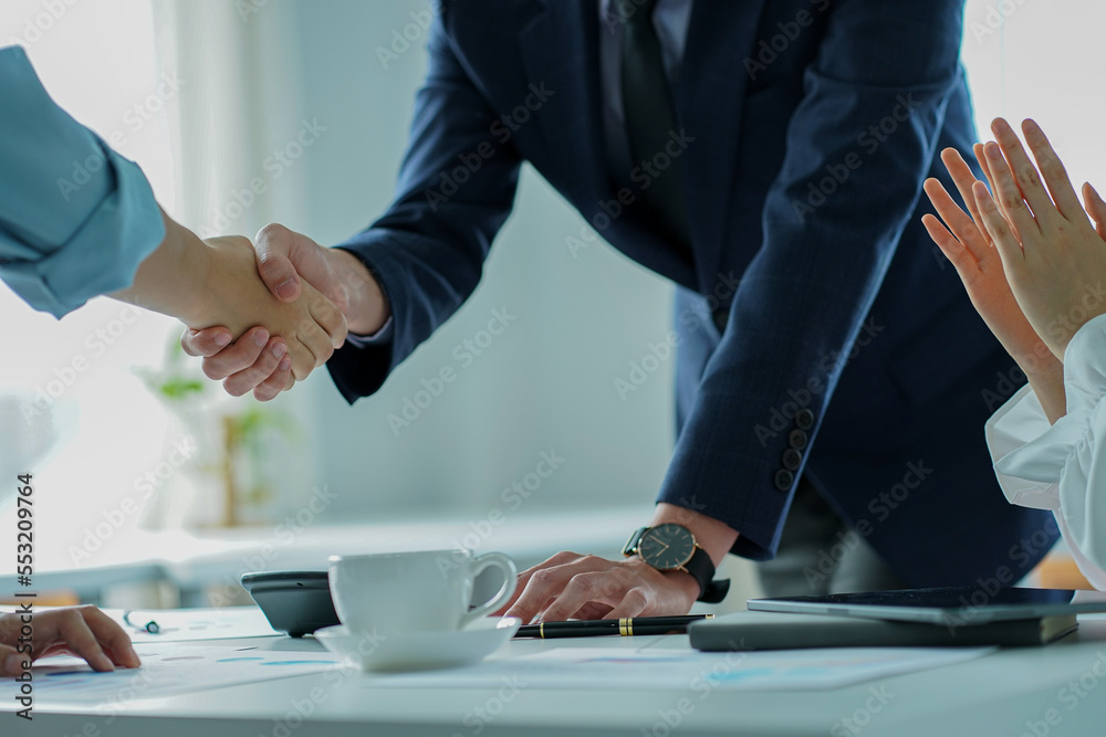 Foto Businessmen shaking hands with clients in modern conference room ...