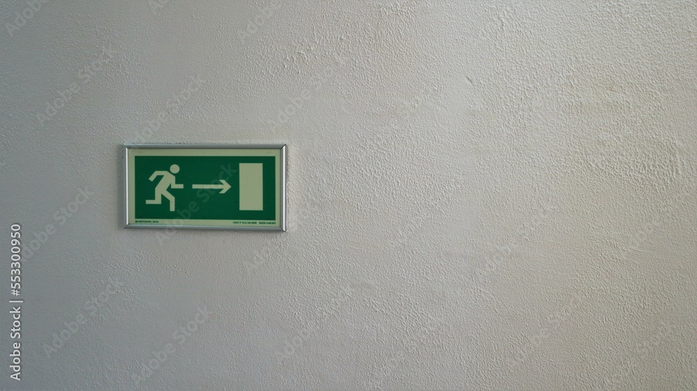 green emergency exit sign in case of evacuation from the building in ...