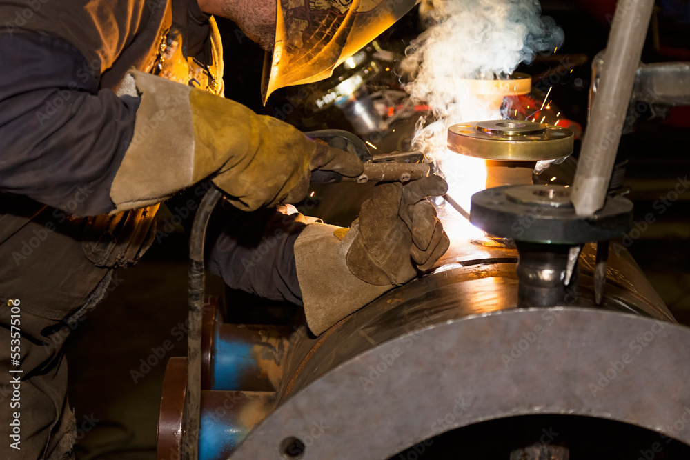 Journeyman pipe fitter welding a nozzle into a three phase separator ...