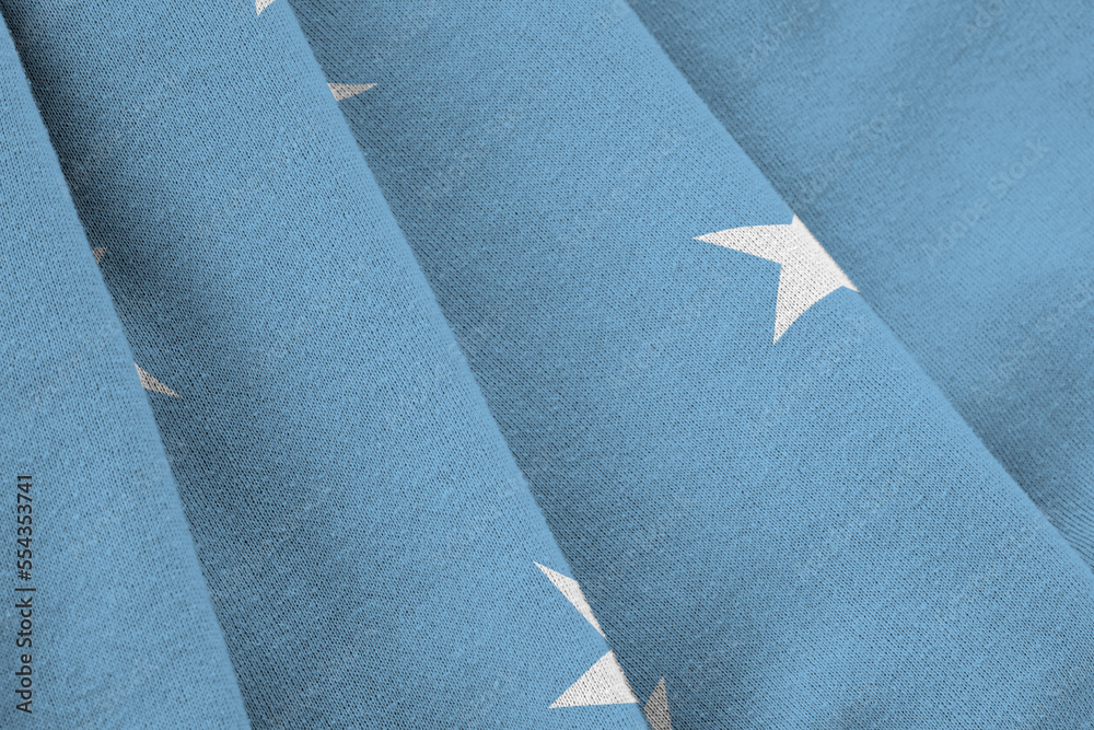 Micronesia flag with big folds waving close up under the studio light ...