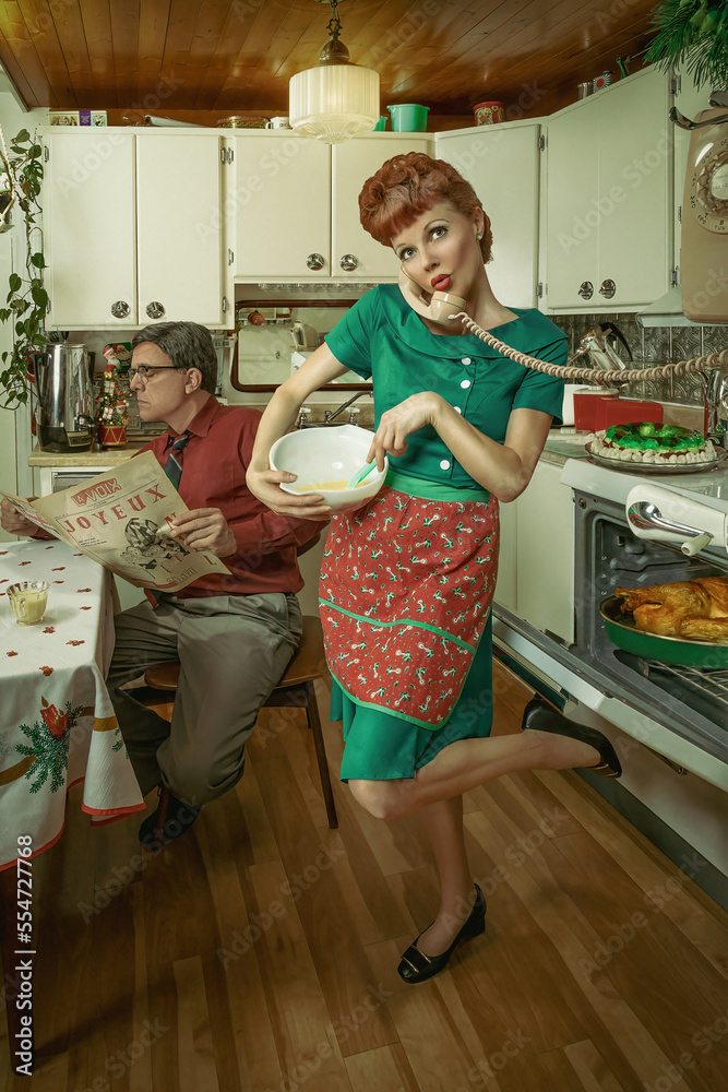 Vintage scene of a wife cooking for a Christmas celebration and talking ...