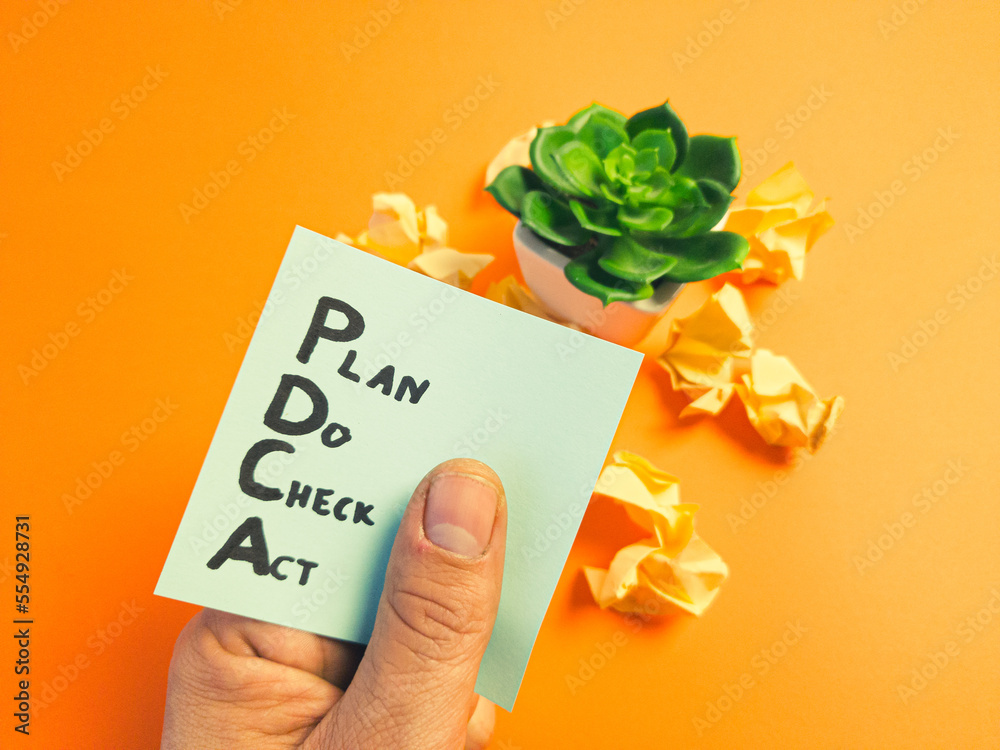 PDCA Plan Do Check Act handwritten on sticky note. Action planning ...