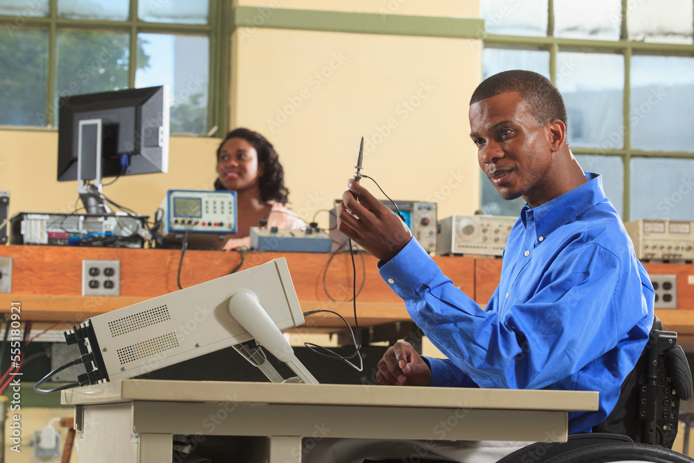 Engineering students in an electronics classroom, one in a wheelchair ...