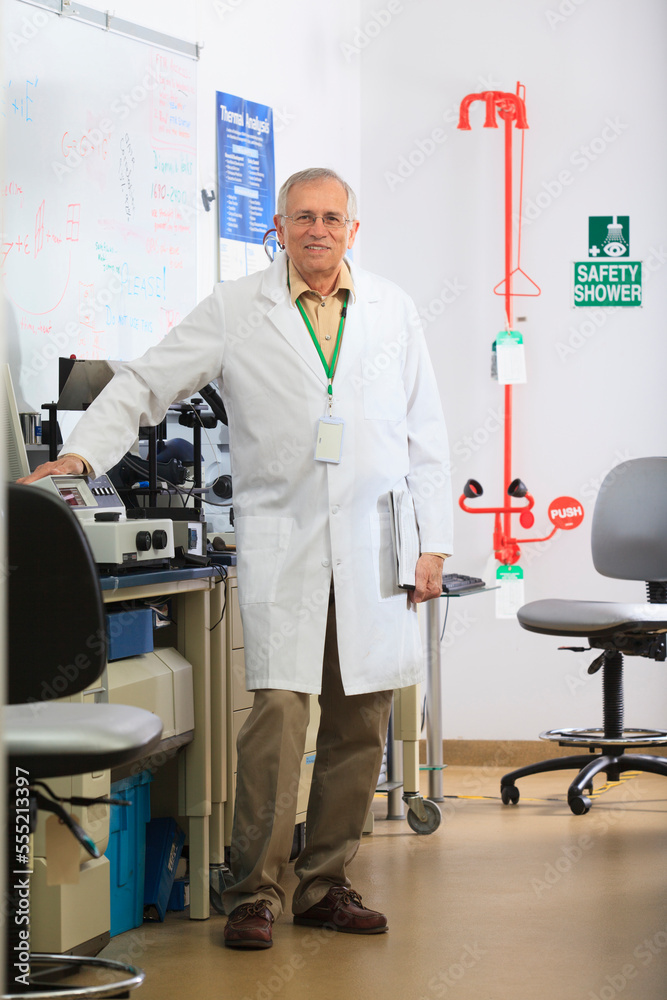 Professor standing beside x-ray fluorescence equipment and safety ...