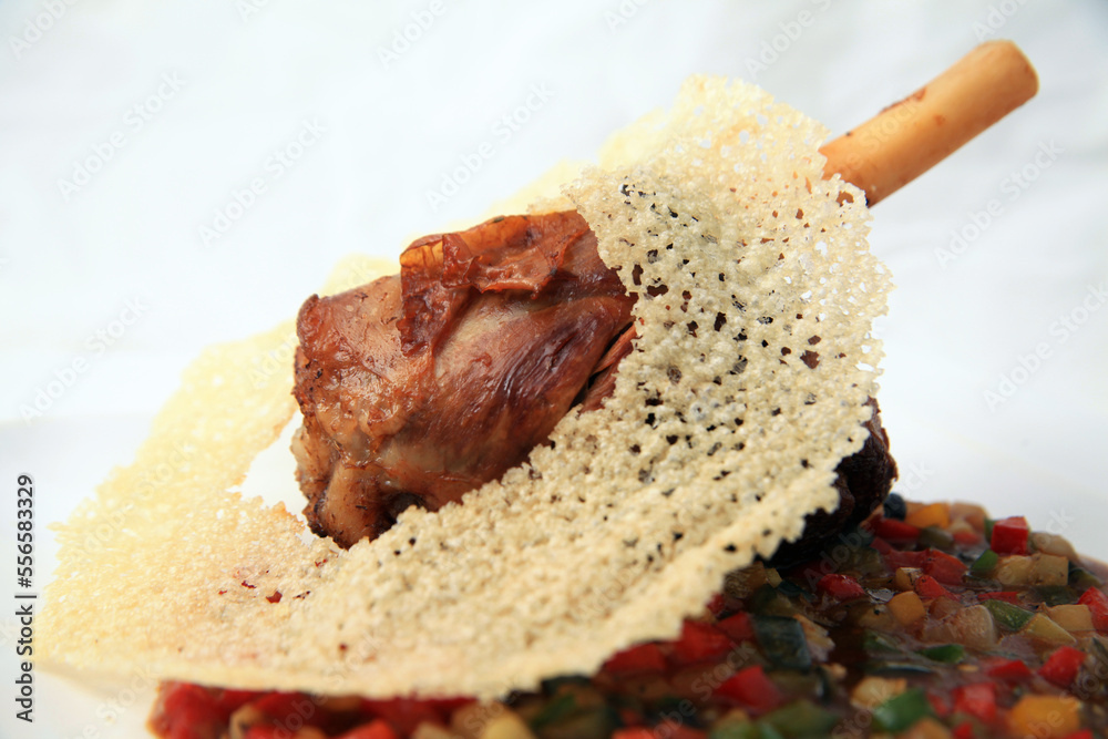 Lamb shank leg on plate white space background isolated with sauce ...