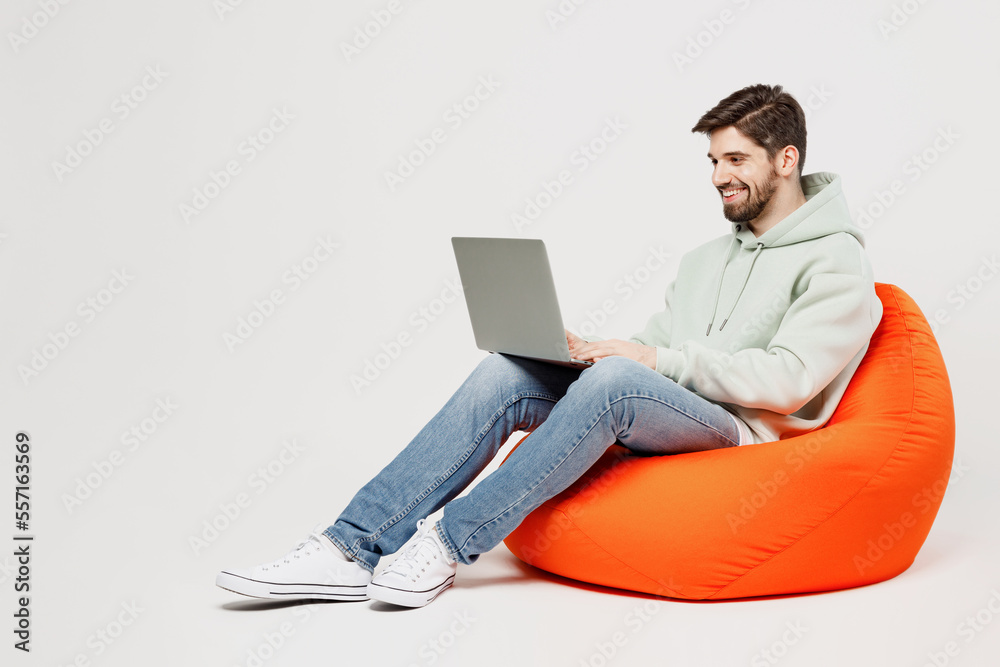 Full body young programmer happy caucasian IT man in mint hoody sit in ...