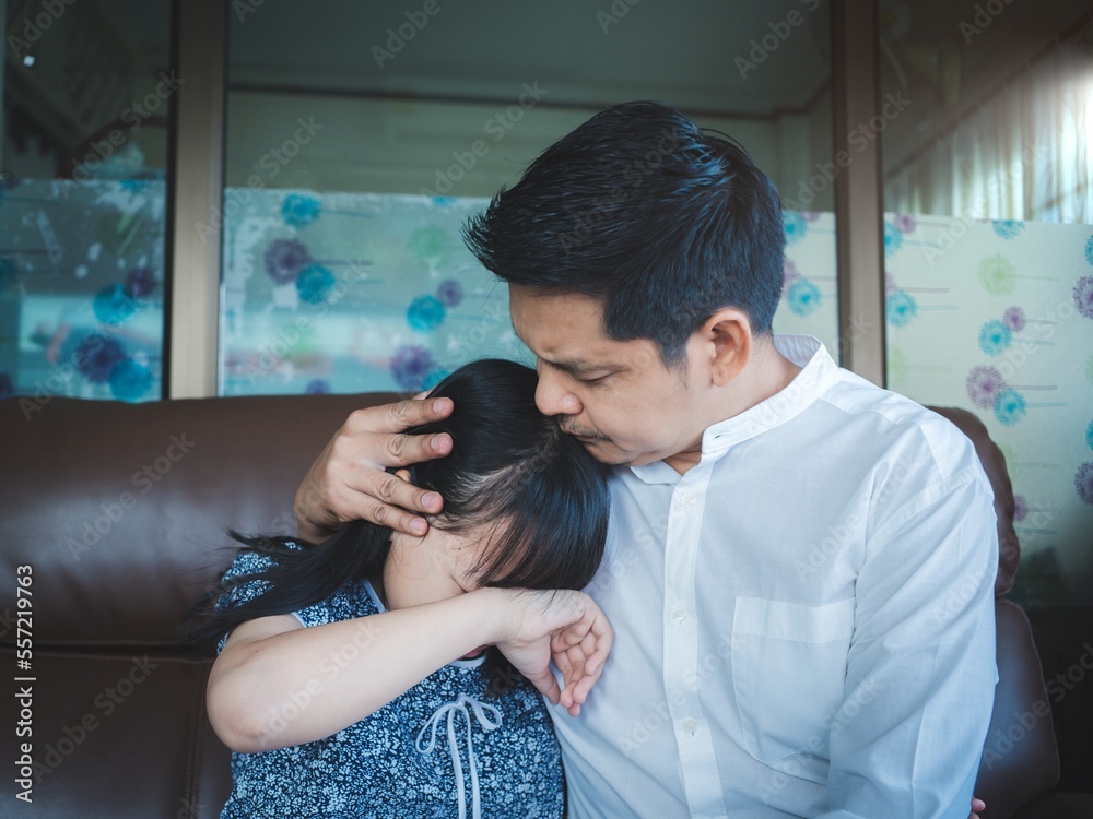 Loving daddy embracing small girl at home,Caring worry asian man ...