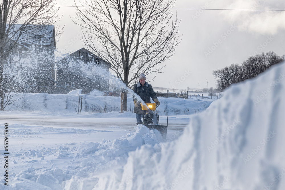 Man snow blowing snow after a big winter storm Stock Photo | Adobe Stock