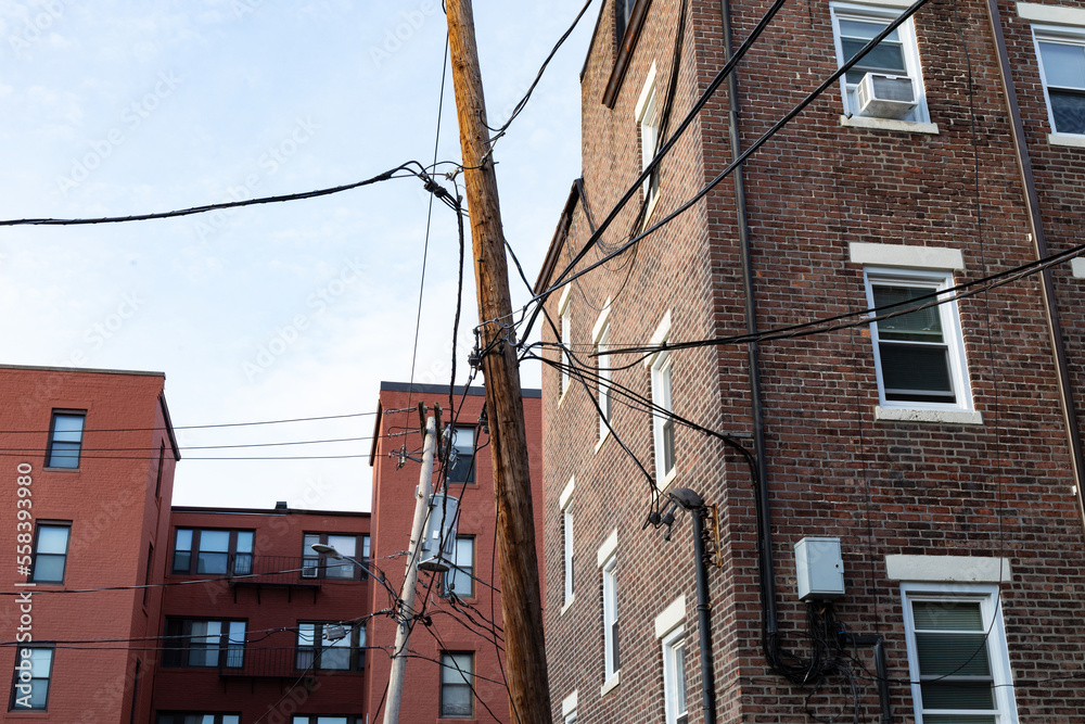 Rear view of old urban brick apartment buildings with power poles and ...