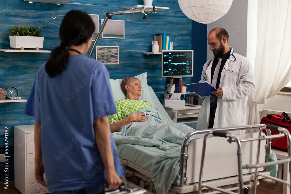 Doctor assisting elderly female patient in health center room ...