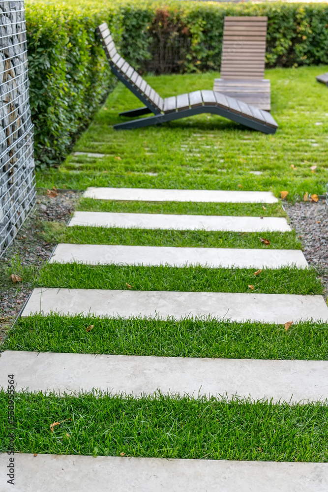 Gray color stepping tiles floor, strip line concrete pavement and green ...