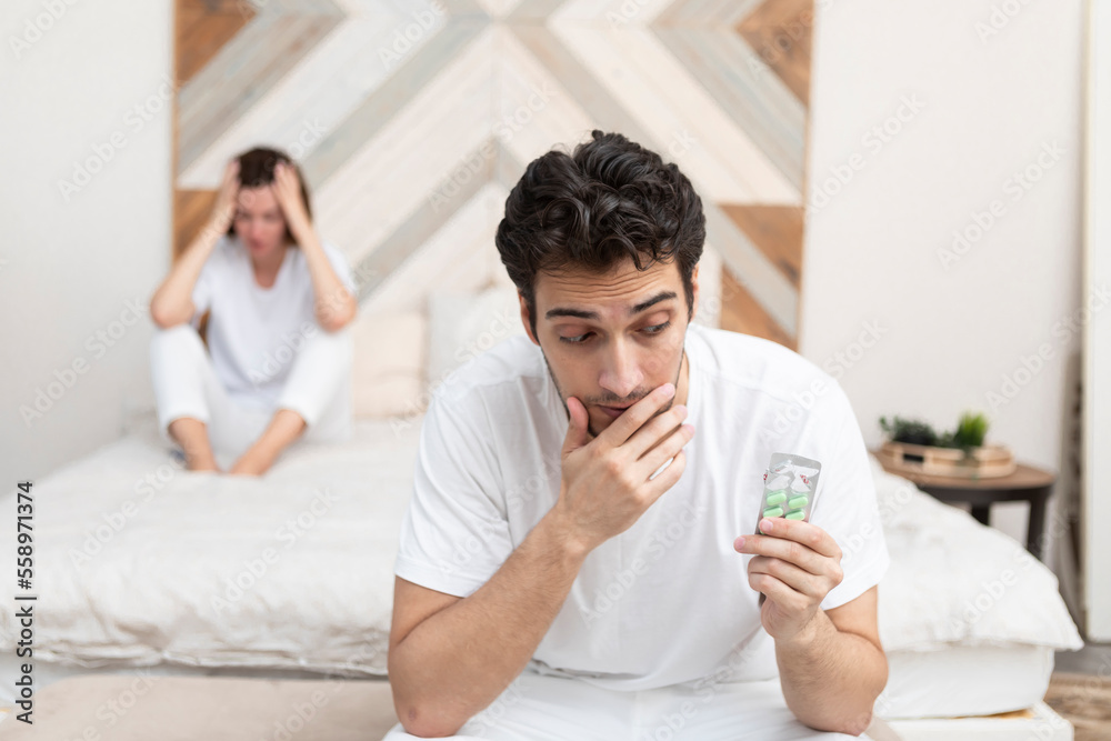 Frustrated and depressed man sitting on the edge of the bed after ...
