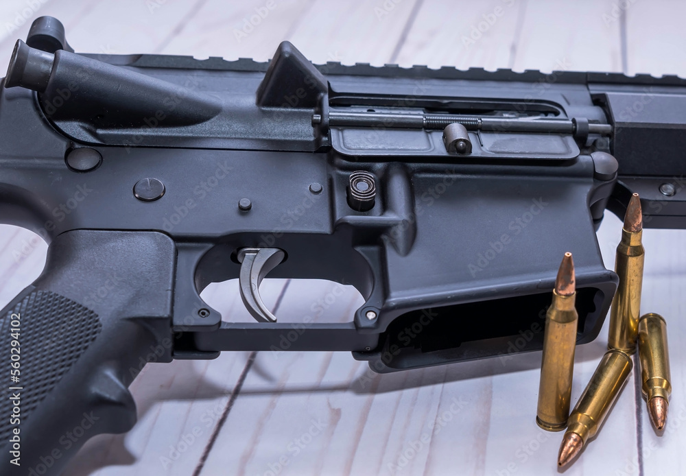 An AR15 rifle chambered in 223 caliber with four bullets next to it on ...
