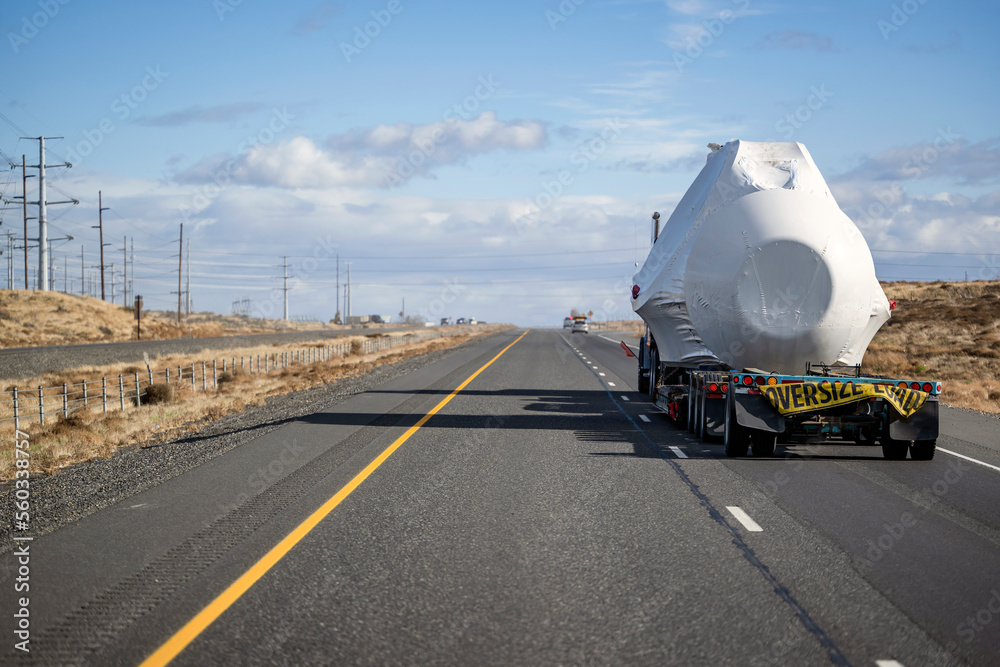 Long hauler big rig semi truck transporting oversize load on the step ...