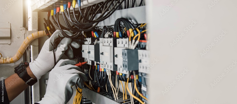 Electrician engineer tests electrical installations and wires on relay ...