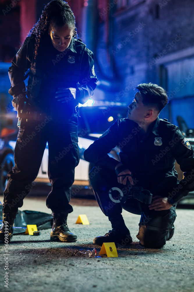 Multiethnic Police Officers Discussing Evidence Found on Crime Scene ...