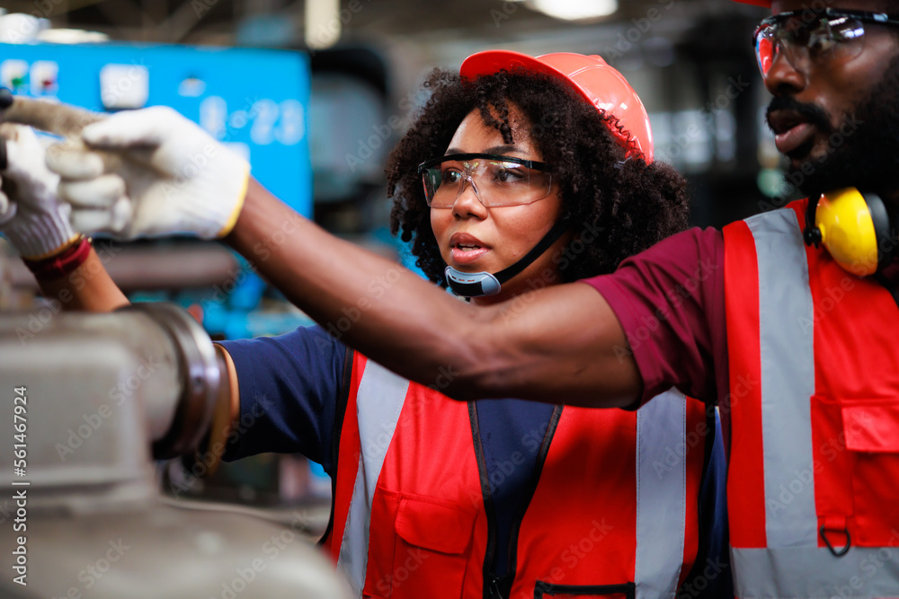 Black Woman worker wearing safety goggles control lathe machine to ...