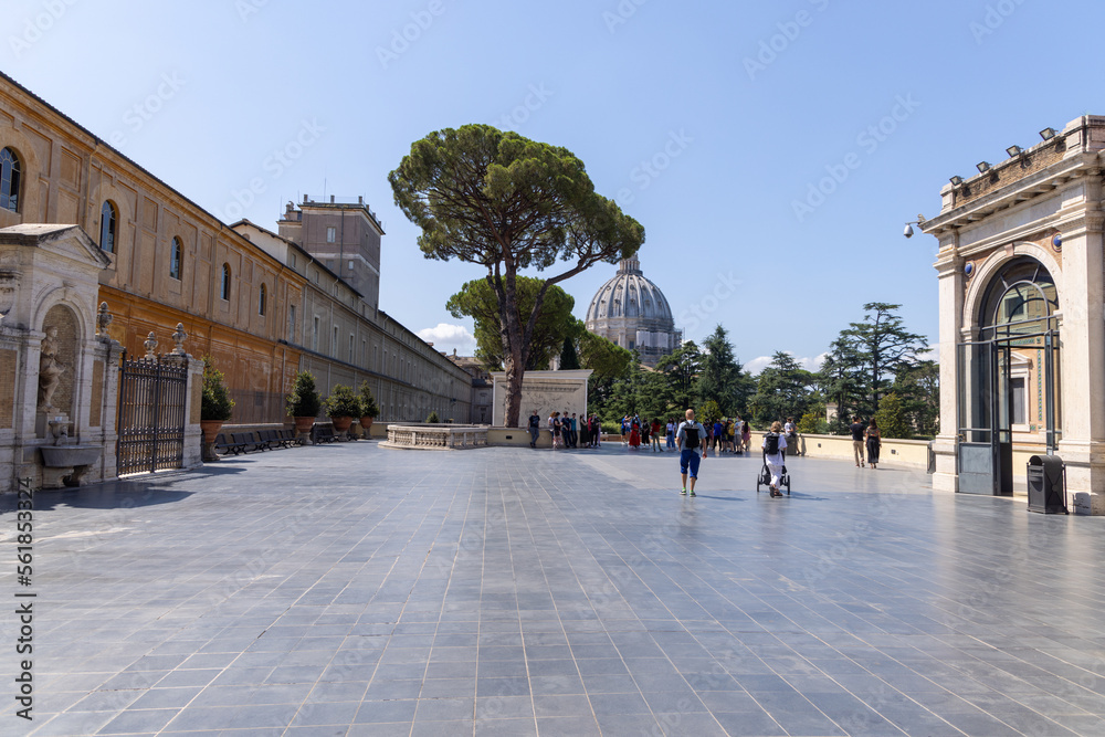 Inner courtyard of Vatican city museum with visitors and St. Peters ...