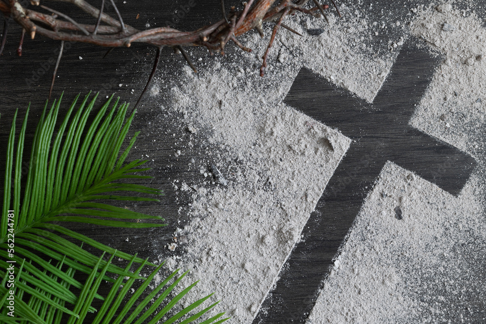 Lent background with cross of ashes, palm leaves and partial crown of ...
