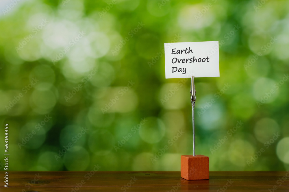 There is a piece of paper with the word Earth Overshoot Day. It is eye ...