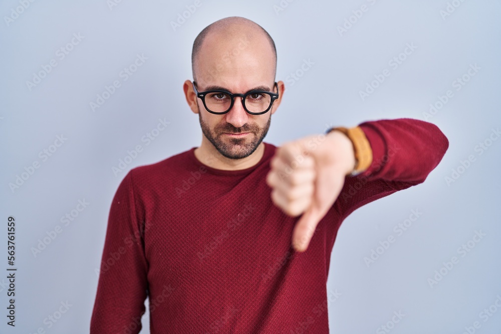 Young bald man with beard standing over white background wearing ...