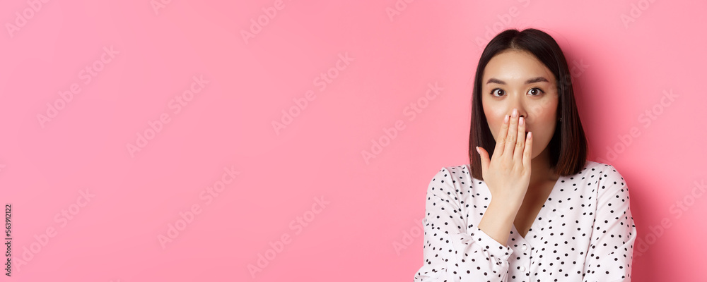 Image of shocked asian girl gossiping, gasping and cover mouth, stare ...